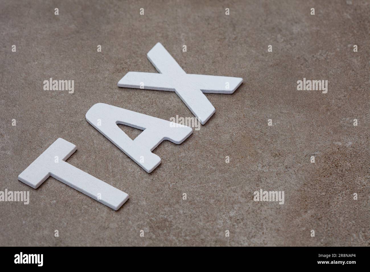 Tax written in white letters on raw cement background, cold and empty ...