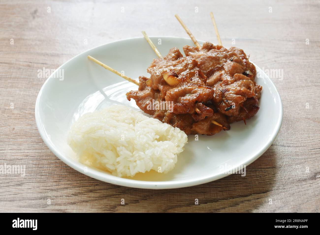 grilled pork in wooden stick eat with sticky rice on dish Stock Photo ...