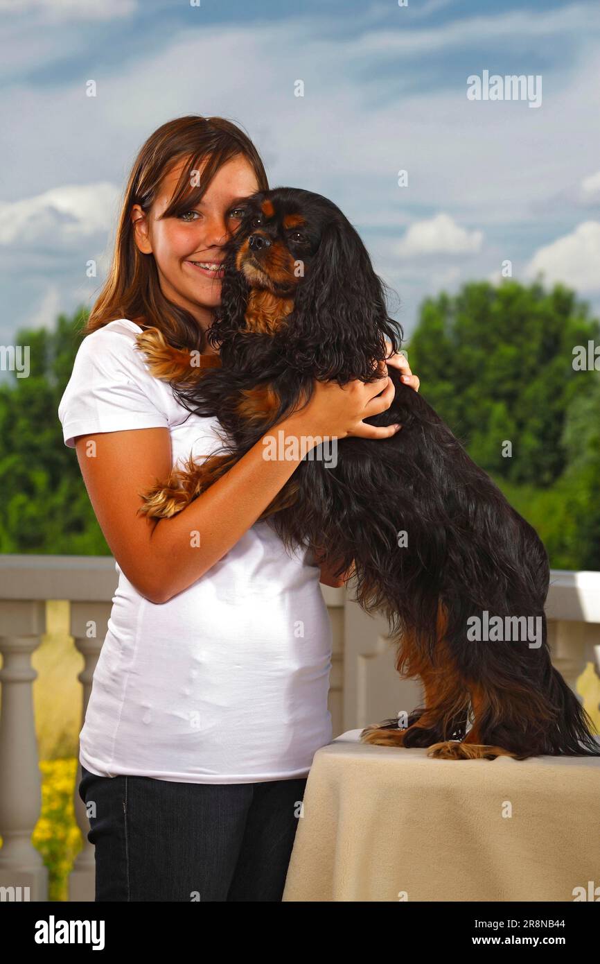 Girl with Cavalier King Charles Spaniel, black-and-tan Stock Photo - Alamy