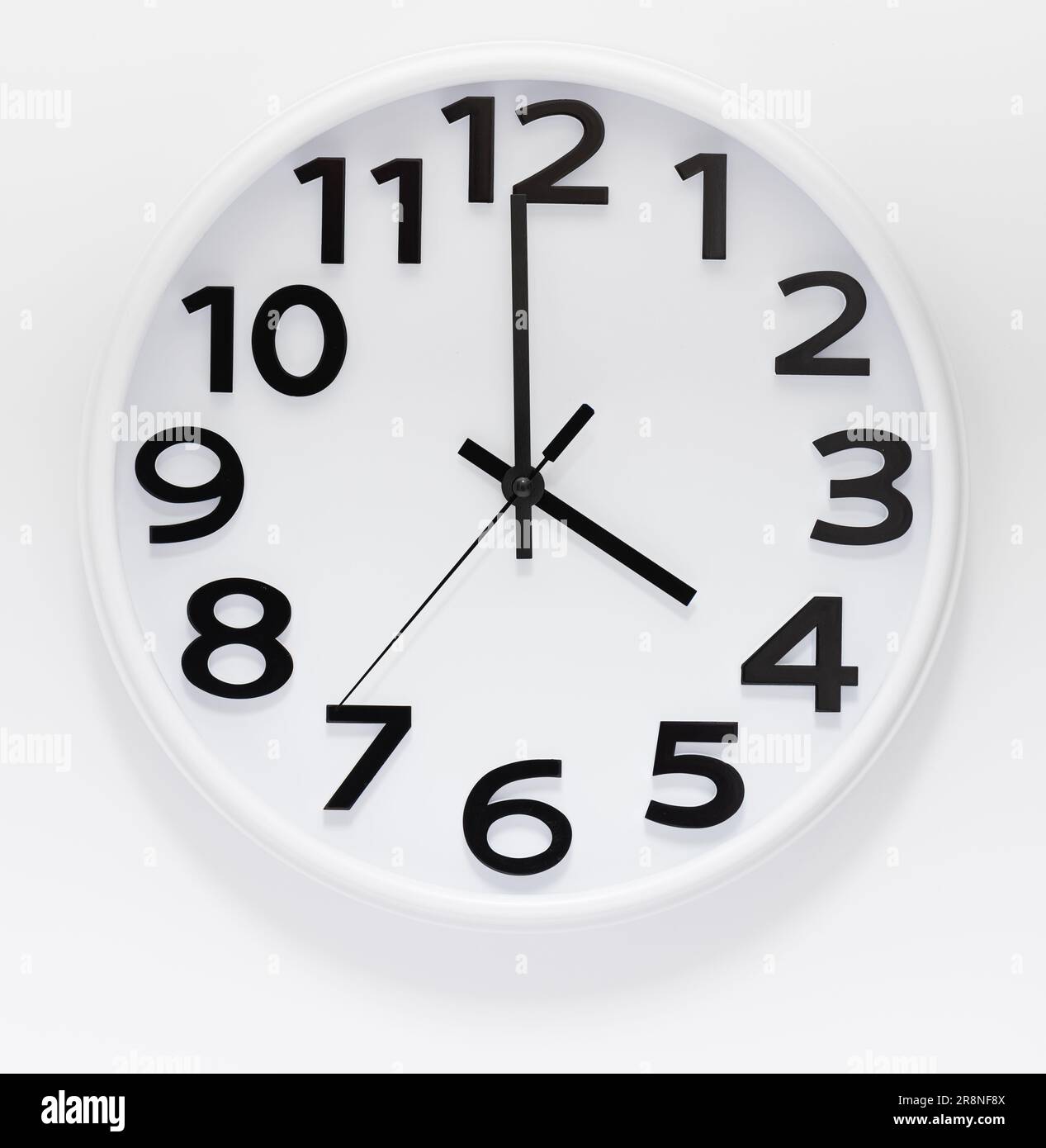 White big analogue simple wall clock isolated on white background. Close up, time management ...