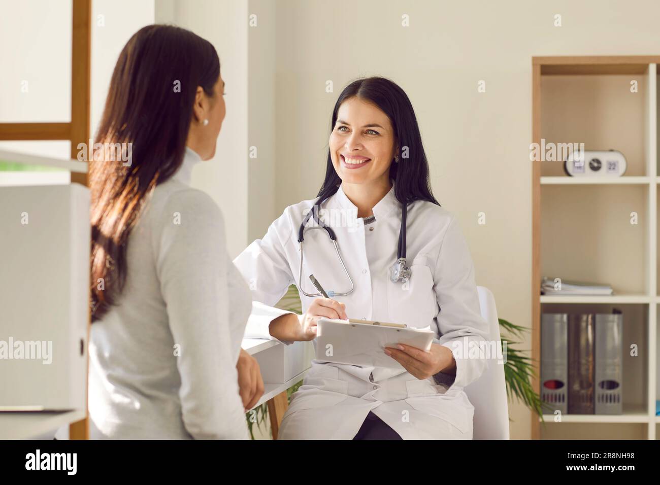 Doctor holding report file with appointment and giving consultation to ...