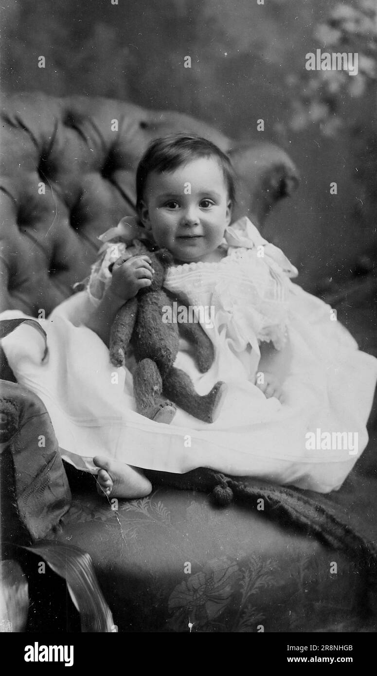 A portrait of a baby girl clutching a teddy bear, c1914. From a ...