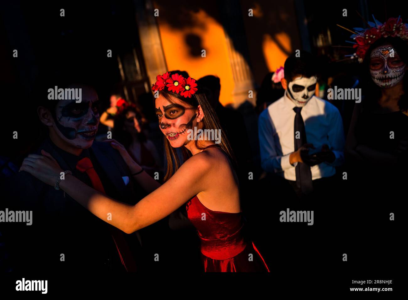 A Mexican woman, dressed as La Catrina, and Mexican men, dressed as ...