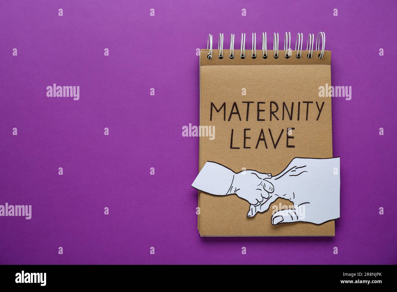 Notepad with words Maternity Leave and paper cutout of hands on purple ...