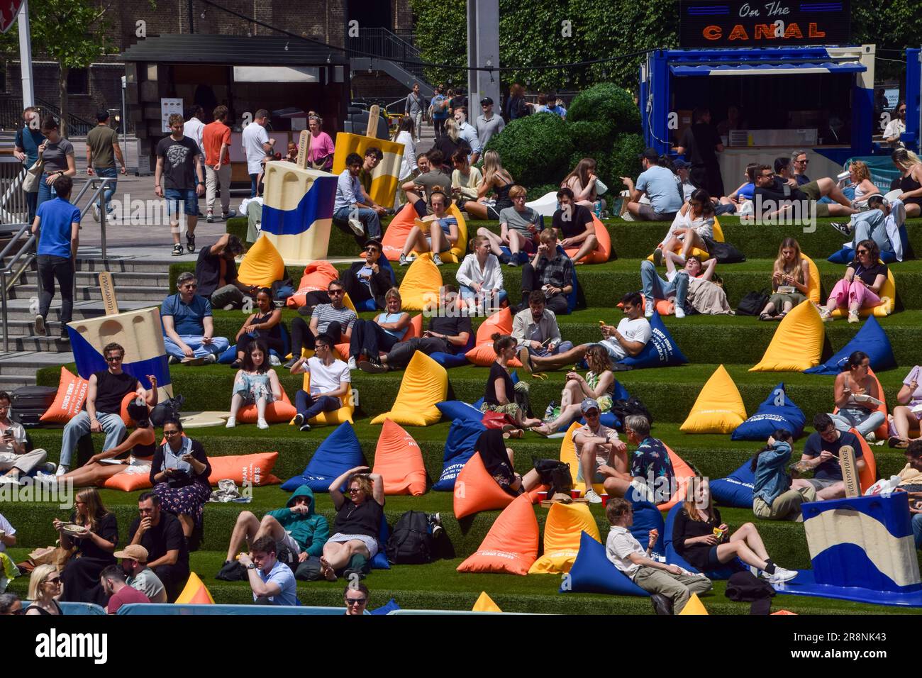 London, UK. 22nd June 2023. Crowds soak up the sun next to giant 'melting ice lollies' on the ...