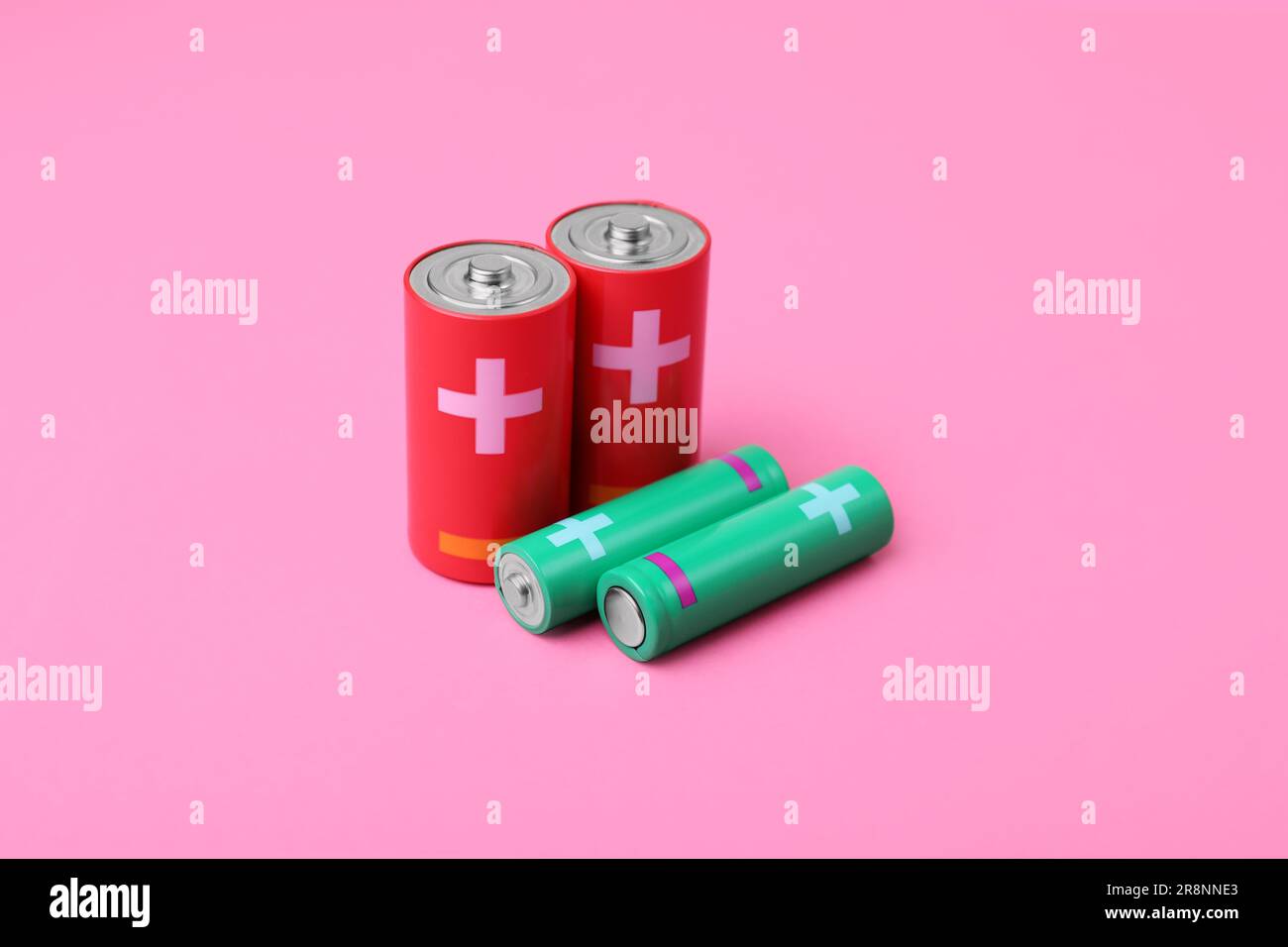 New AA and C sizes batteries on pink background Stock Photo - Alamy