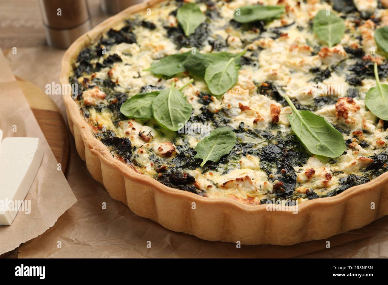 Delicious homemade spinach quiche parchment paper, closeup Stock Photo ...