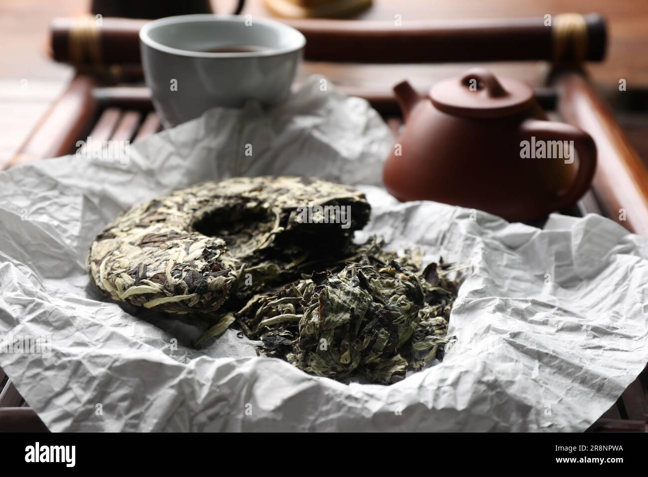 Broken disc shaped pu-erh tea on tray, closeup. Traditional ceremony ...