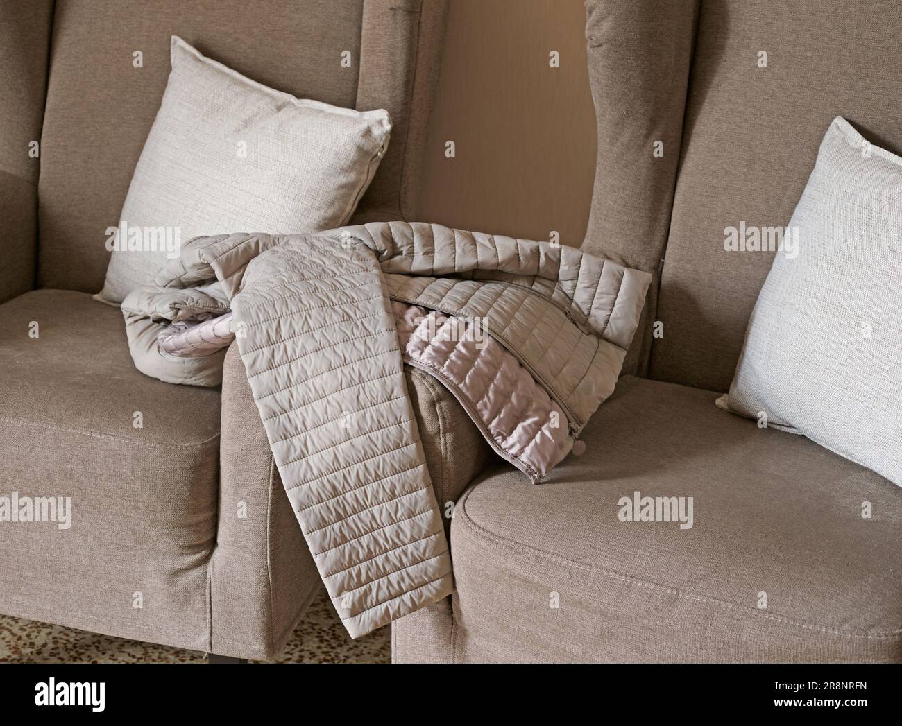 beige female jacket lying over armchairs in living room Stock Photo - Alamy