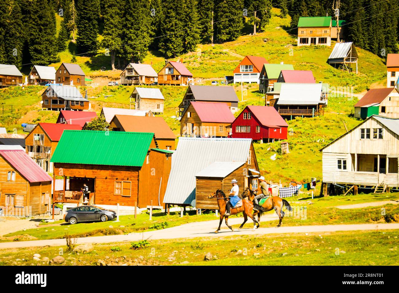 Two horse rider in BAkhmaro village by colorful traditional houses in ...