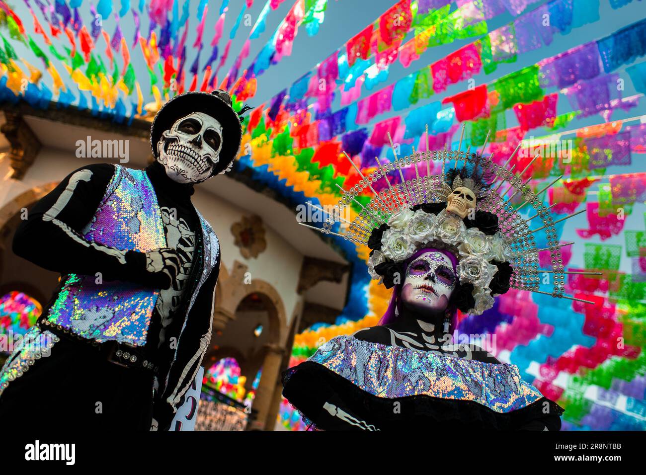 A Mexican woman, dressed as La Catrina, and a Mexican man, dressed as ...