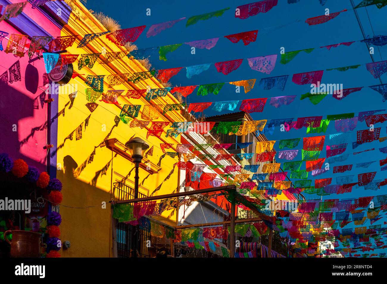 Pecked paper flags (papel picado) are seen attached to lines and hung ...