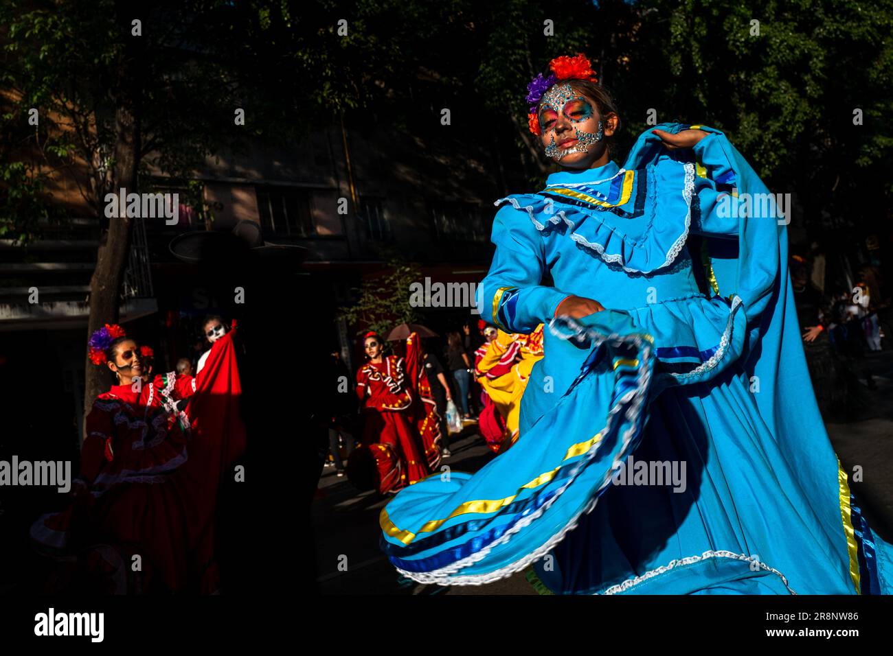 A young Mexican woman, dressed as La Catrina, performs a dance act ...