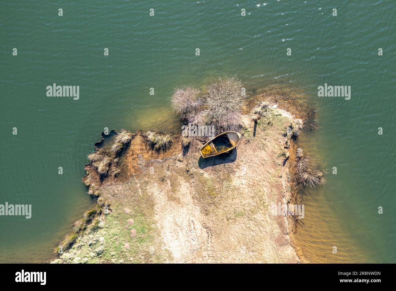 Aerial view of a small, bright yellow boat sitting on a peaceful ...