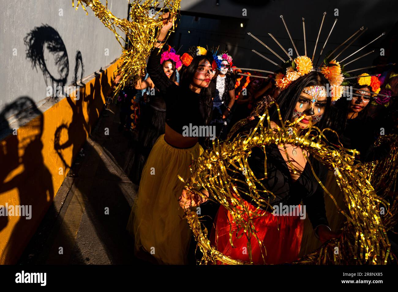 Young Mexican women, wearing La Catrina face paint, perform a dance act ...