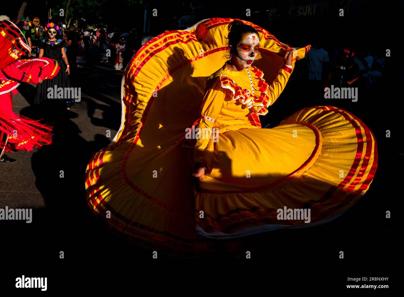 A young Mexican woman, dressed as La Catrina, performs a dance act ...