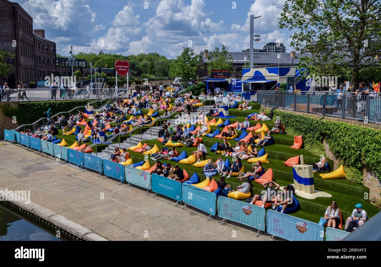London, UK. 22nd June, 2023. People enjoy the sunshine next to giant ...