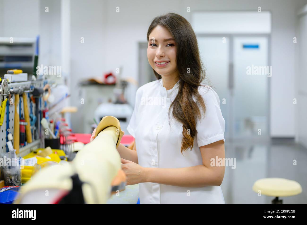 Technician holding prosthetic limb checking and working in laboratory ...