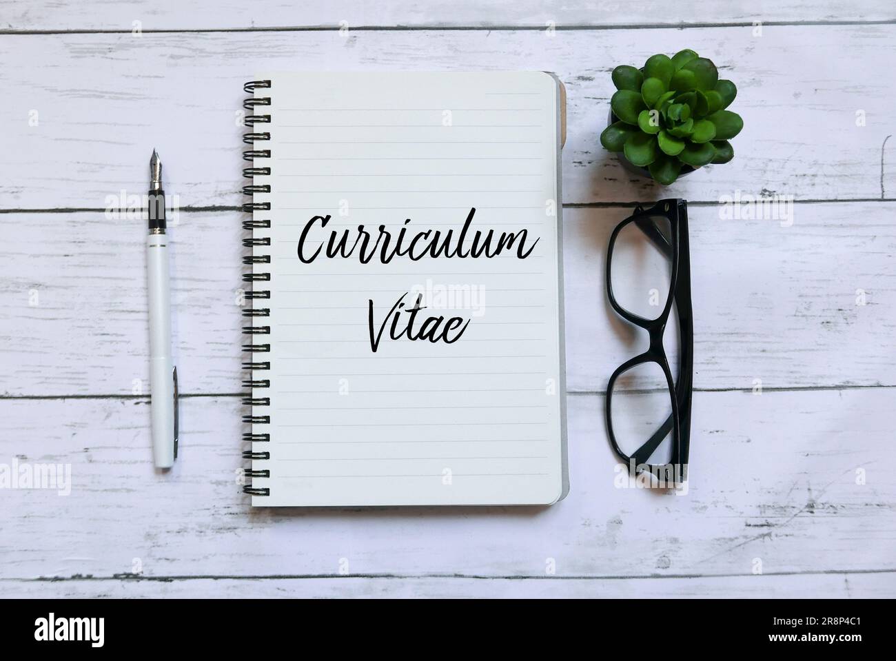 Top view of glasses,pen and notebook written with Curriculum Vitae on ...