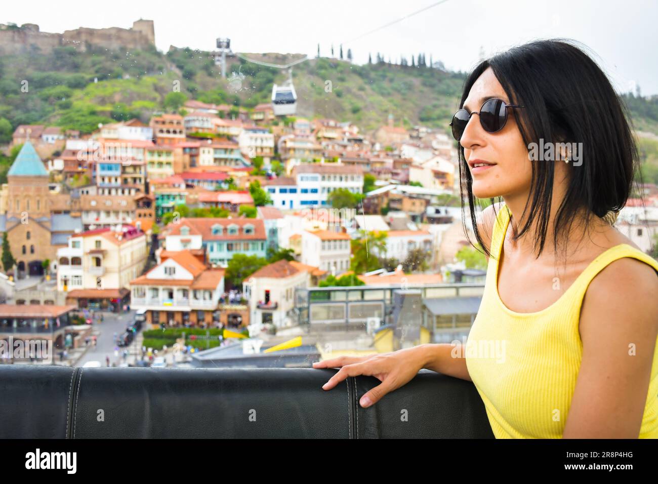 Attractive caucasian female enjoy view of Tbilisi city in cable car ...