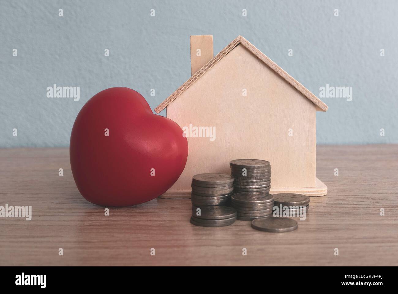 A stack of coins,a house model and red heart love on table Stock Photo ...