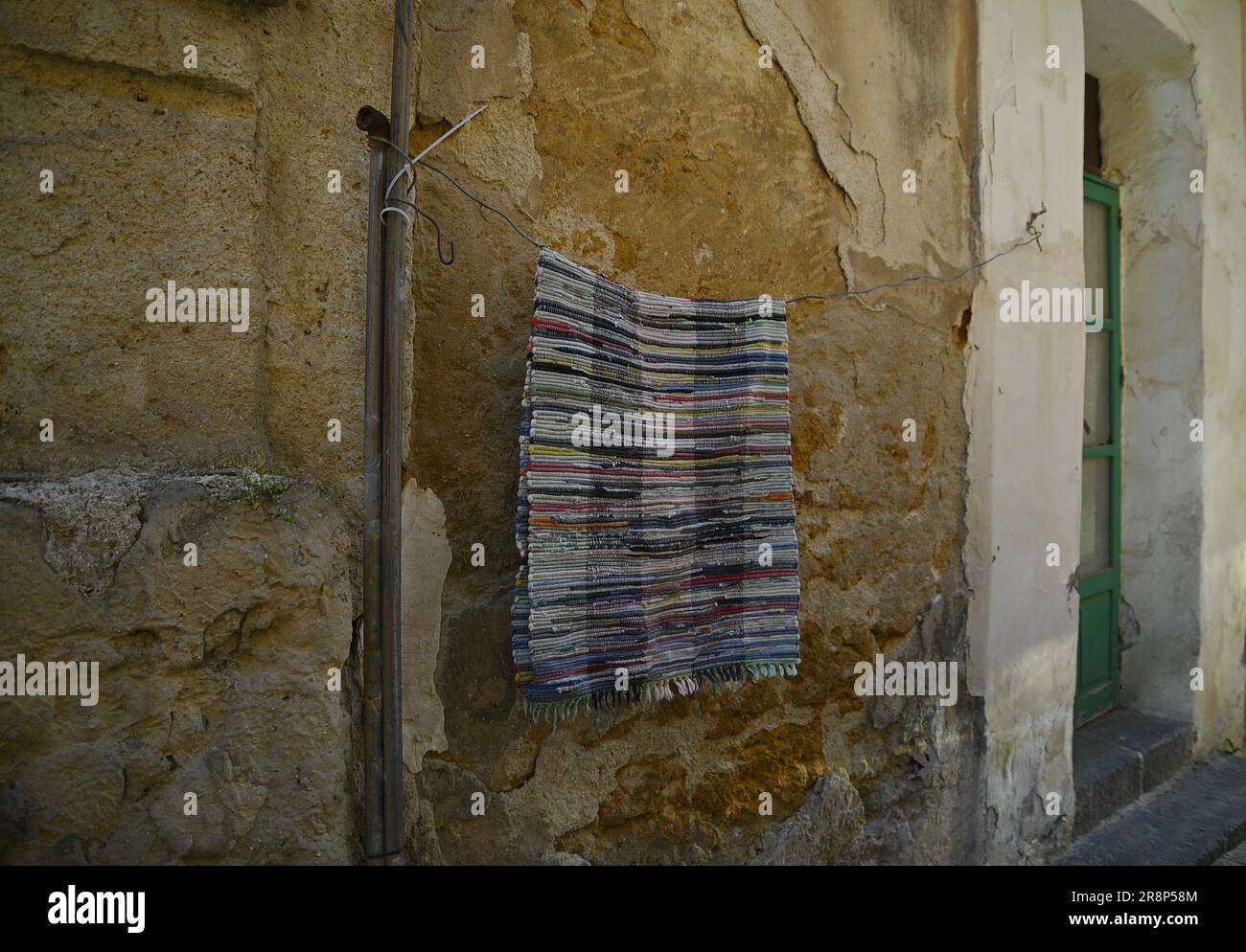Traditional handwoven colorful kourelou rug against a textured ochre ...