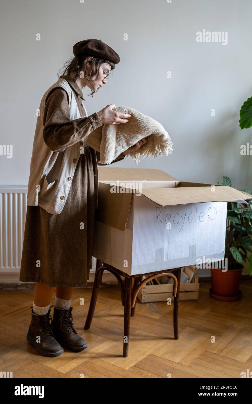 Hipster girl sorting clothing items for recycling Stock Photo - Alamy