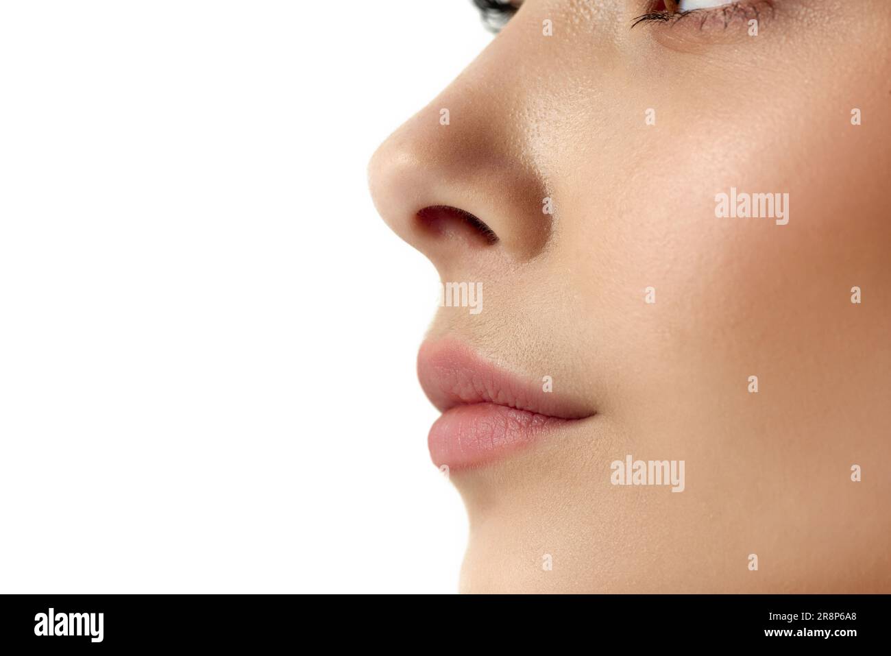Cropped, close-up profile image of female face part, nose and lips ...