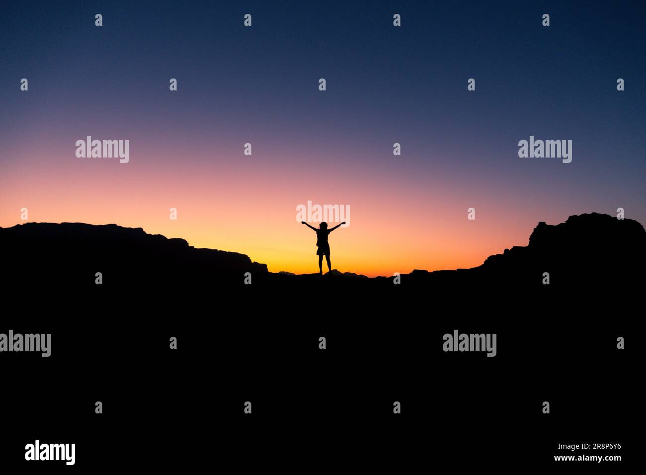 Silhouette of free cheering woman hiker open arms at mountaintop greet ...