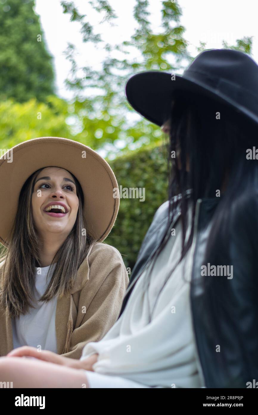 Two friends laughing and enjoying each other's company while sitting in ...