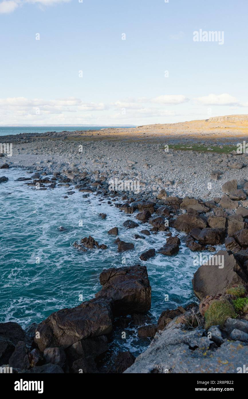 A scenic beach with an expansive body of water and rocky outcroppings ...