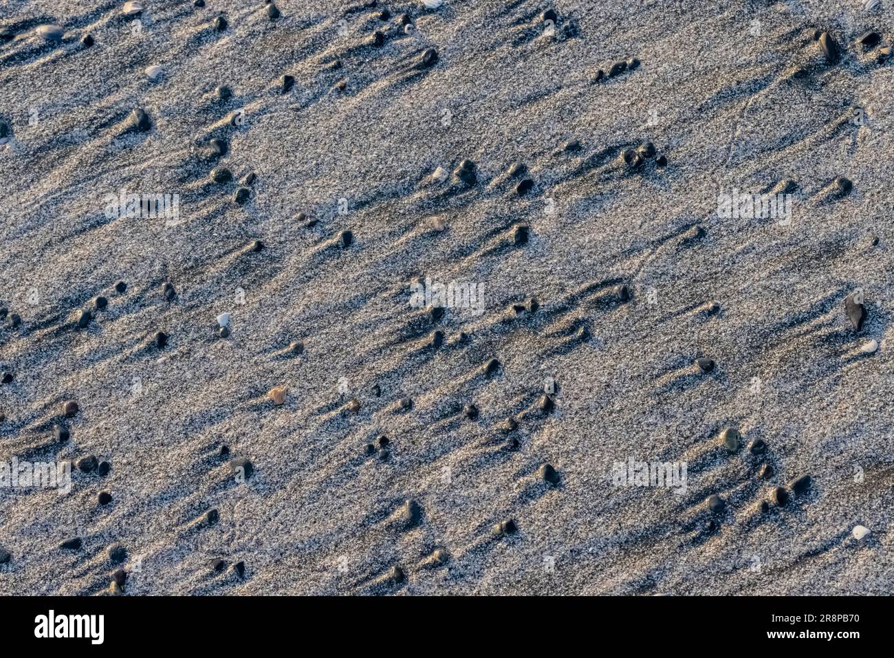 Patterns made by receding wave flowing around little stones on Hobuck ...