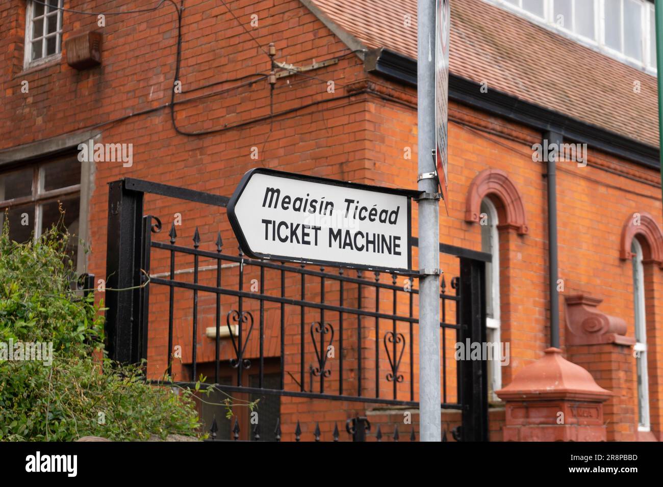 A ticket machine sign on the pole against a backdrop of a red brick ...
