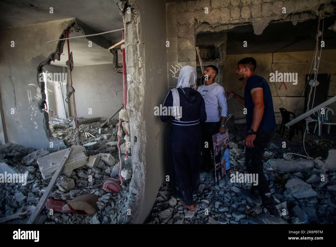 Palestinians inspect a destroyed house of the Palestinian imprisoned ...