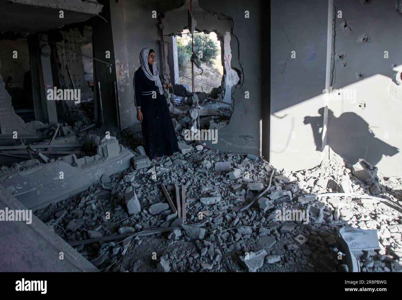A Palestinian lady inspects a destroyed house of the Palestinian ...
