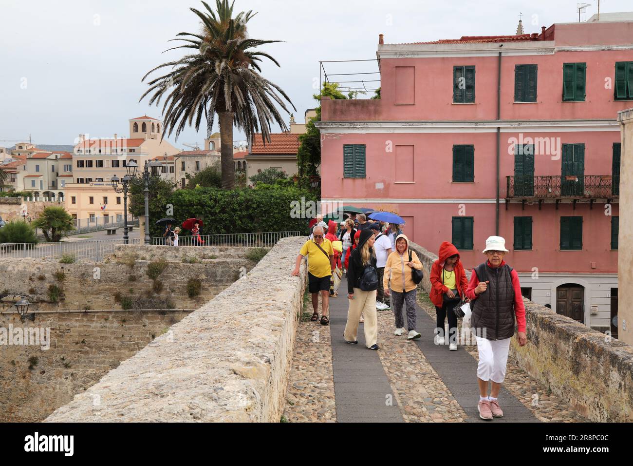 ALGHERO, ITALY - MAY 29, 2023: People take part in a city tour in rainy ...