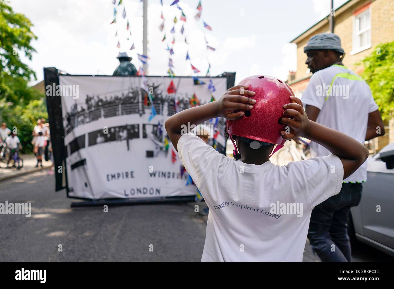 A screen showing the Windrush ship leads the procession that ...