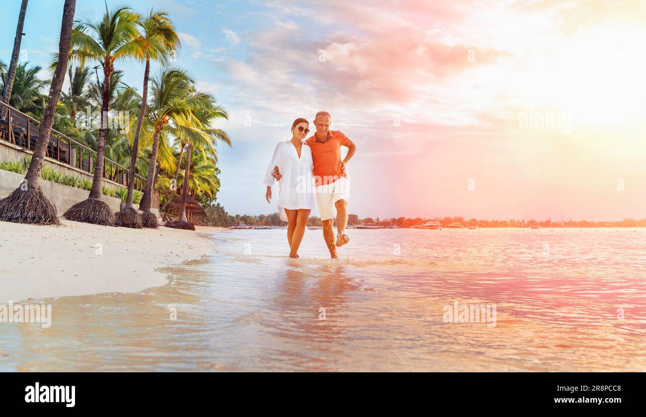 Couple in love hugging while walking on a sandy exotic beach. They have ...