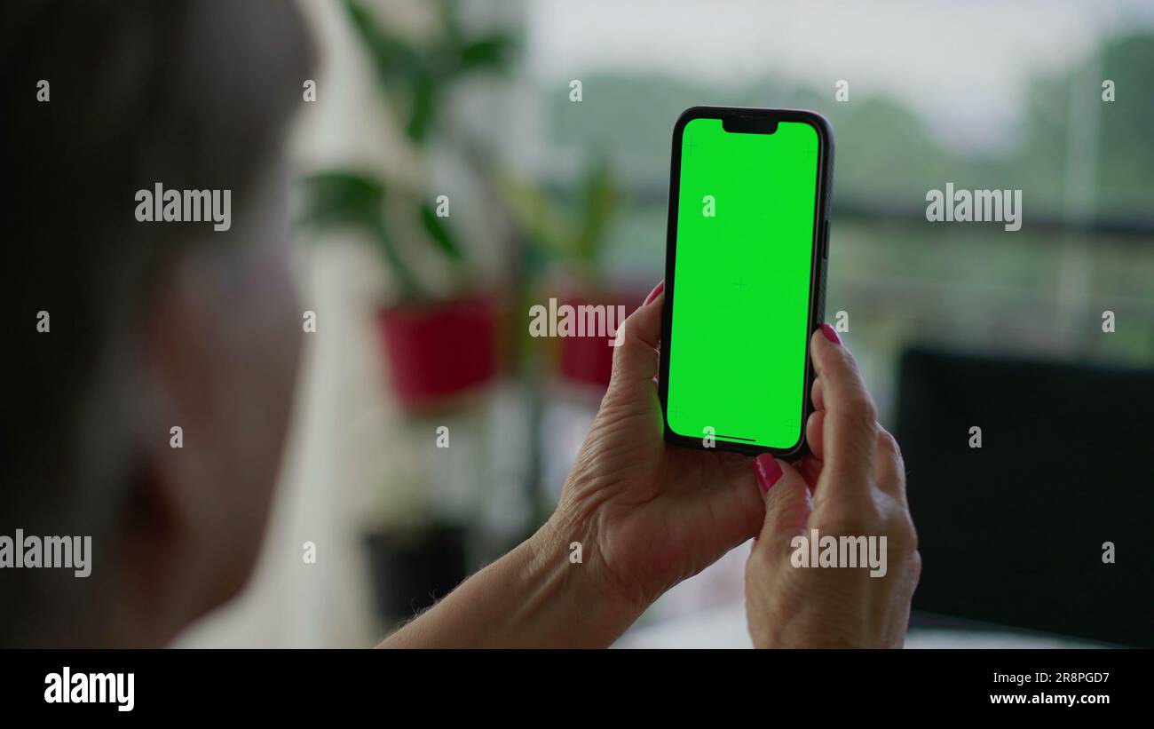 Senior person hands holding smartphone with Chroma key greenscreen ...