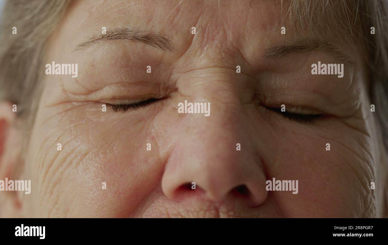 Senior woman closing eyes in contemplation in macro close-up. Eye s ...