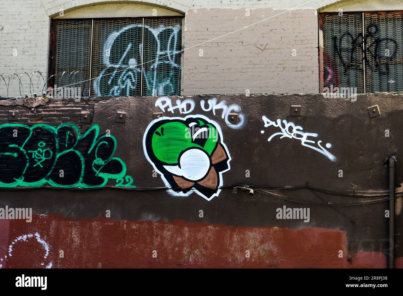 An urban wall adorned with colorful graffiti art located adjacent to a ...