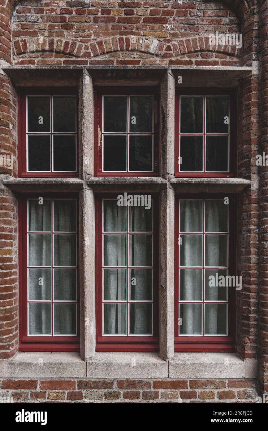 An aged red wooden window adds character to an orange brick house ...