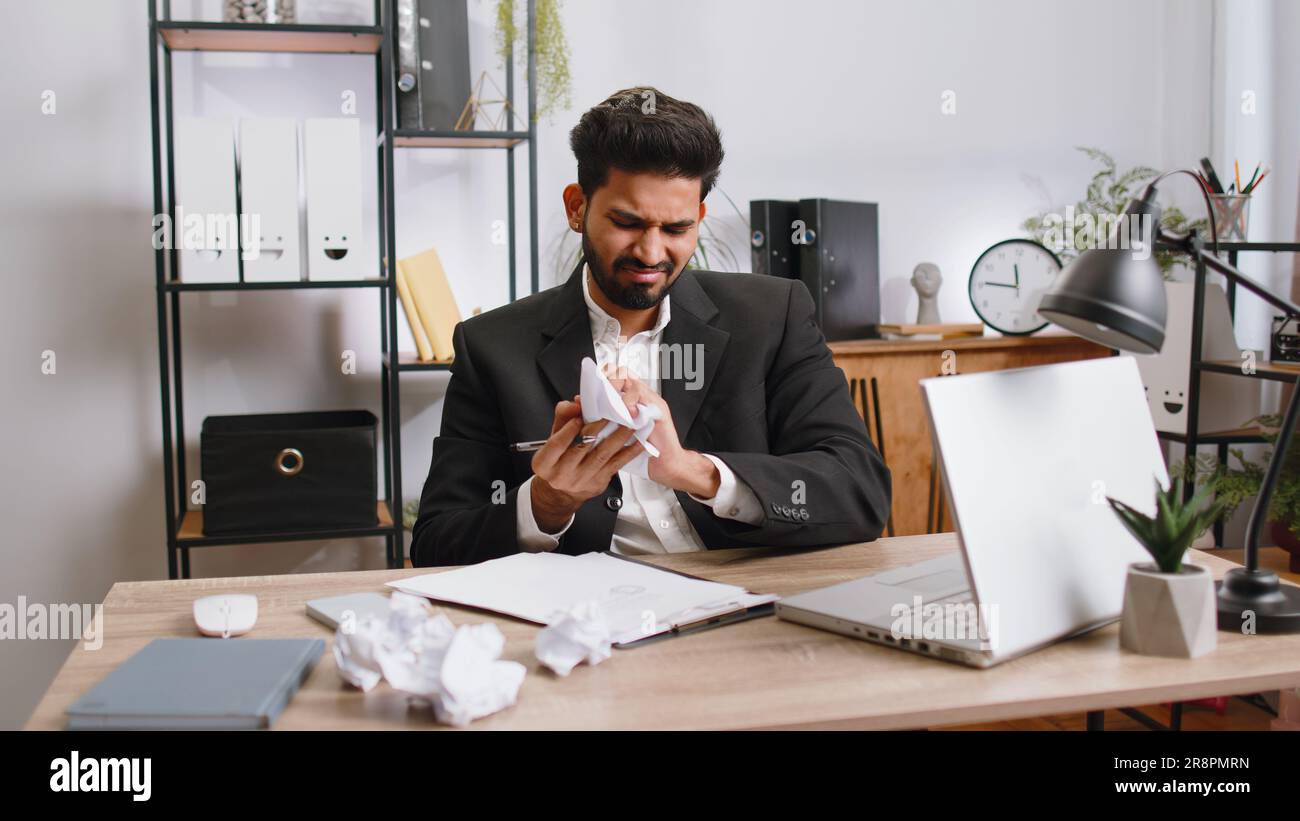 Angry furious indian man working at office throwing crumpled paper ...