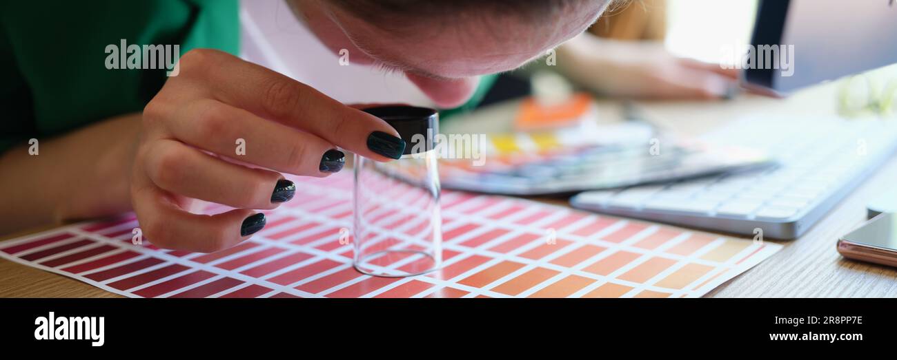Graphic designer looking at colors samples through loupe Stock Photo ...