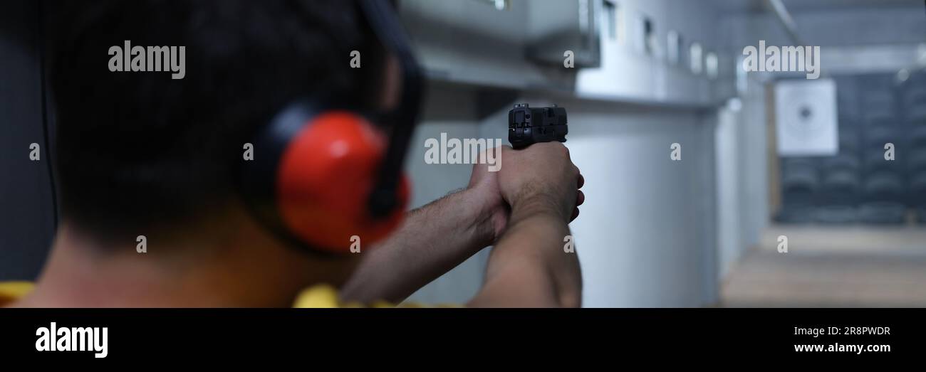 Man shooter in headphones shooting at target Stock Photo - Alamy