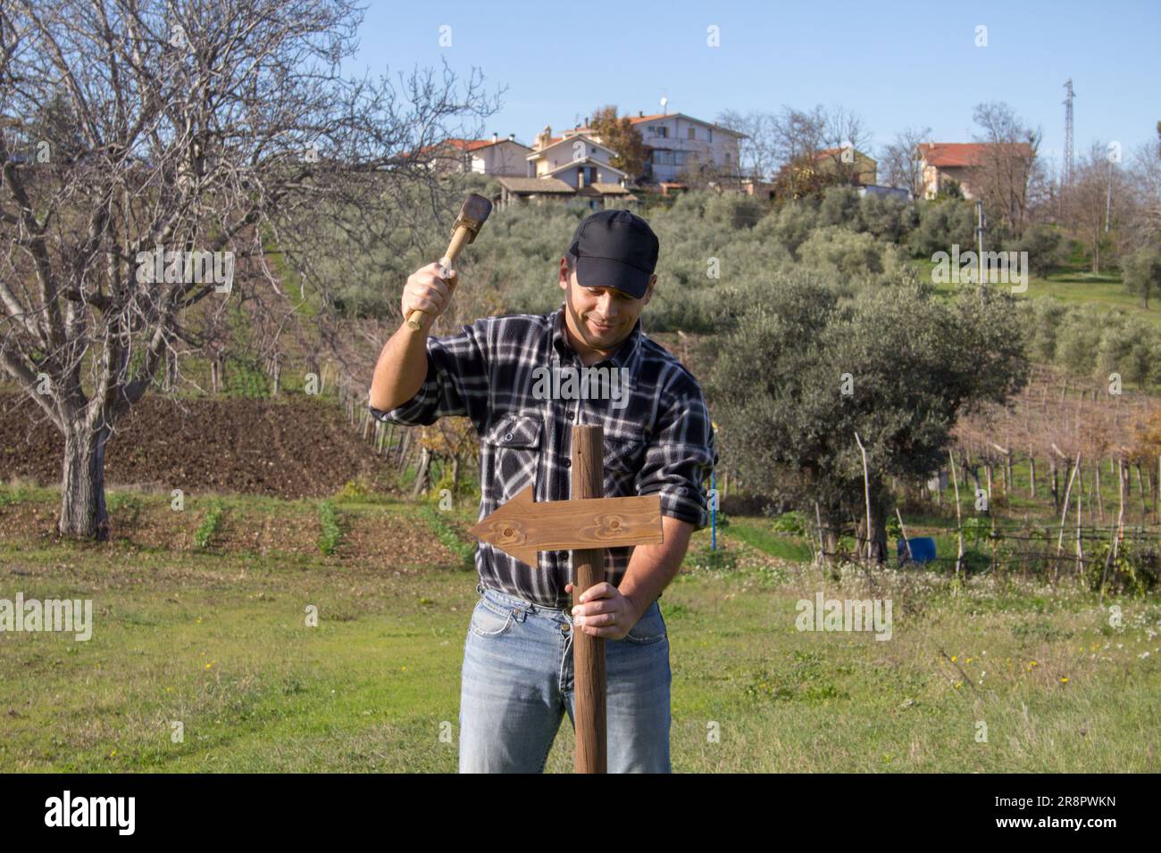 Image of a man driving a stake with an arrow into the ground with a ...