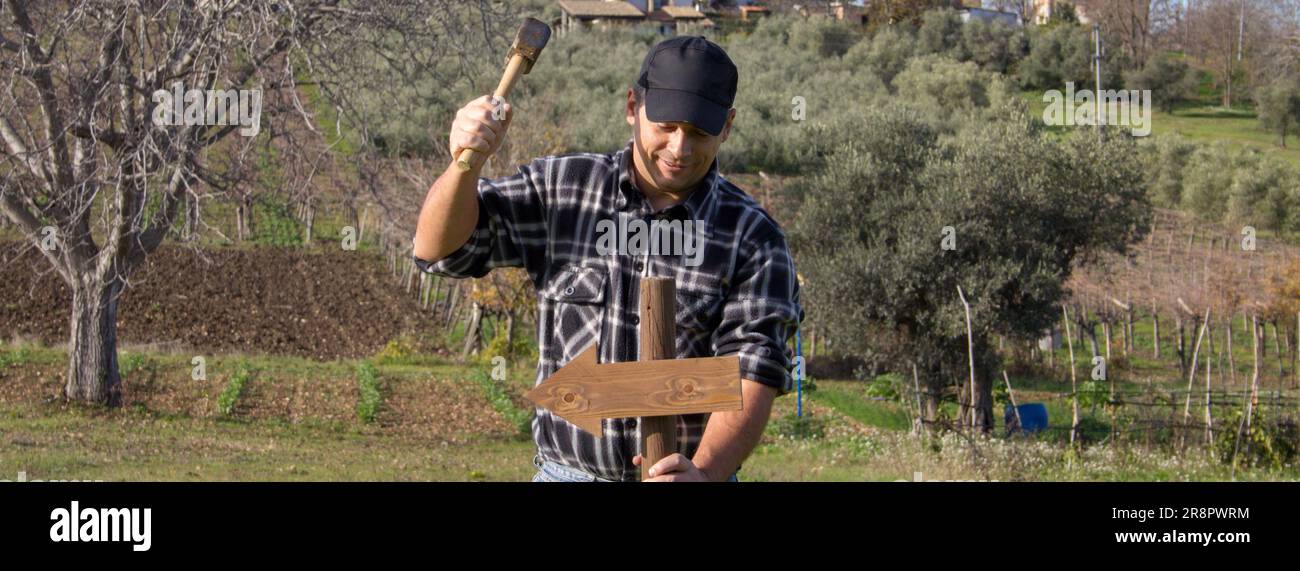 Image of a man driving a stake with an arrow into the ground with a ...
