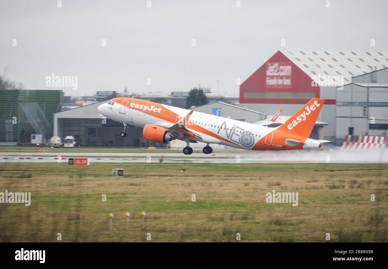 A white and orange jet plane on a tarmac runway at a modern airport ...