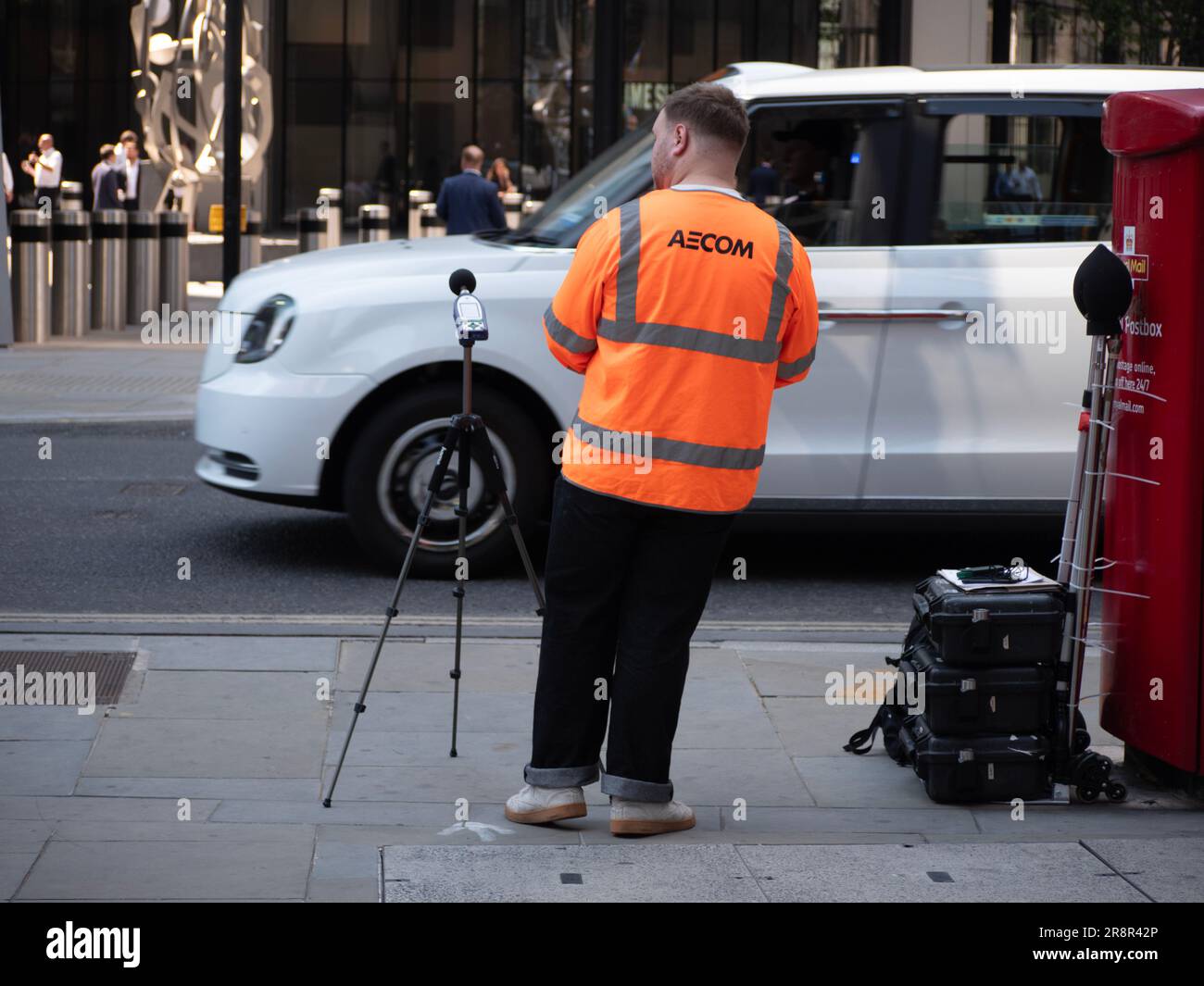 workman working for Aecom measuring sound in street with digital sound ...