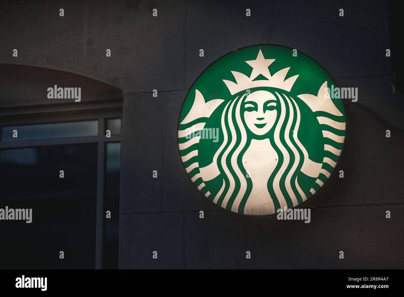 An exterior view of a Starbucks logo displayed on a building Stock ...